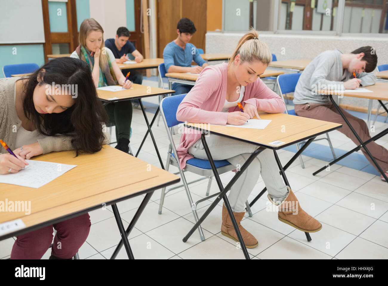 People sitting at the classroom and writing writing Stock Photo - Alamy
