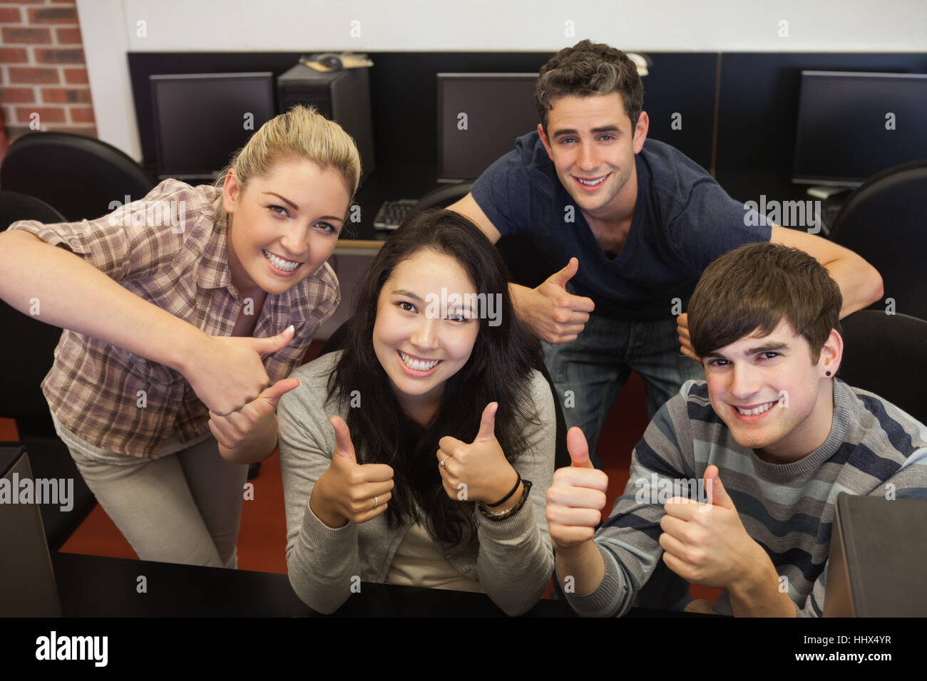 Students giving while thumbs up in college computer room Stock Photo ...