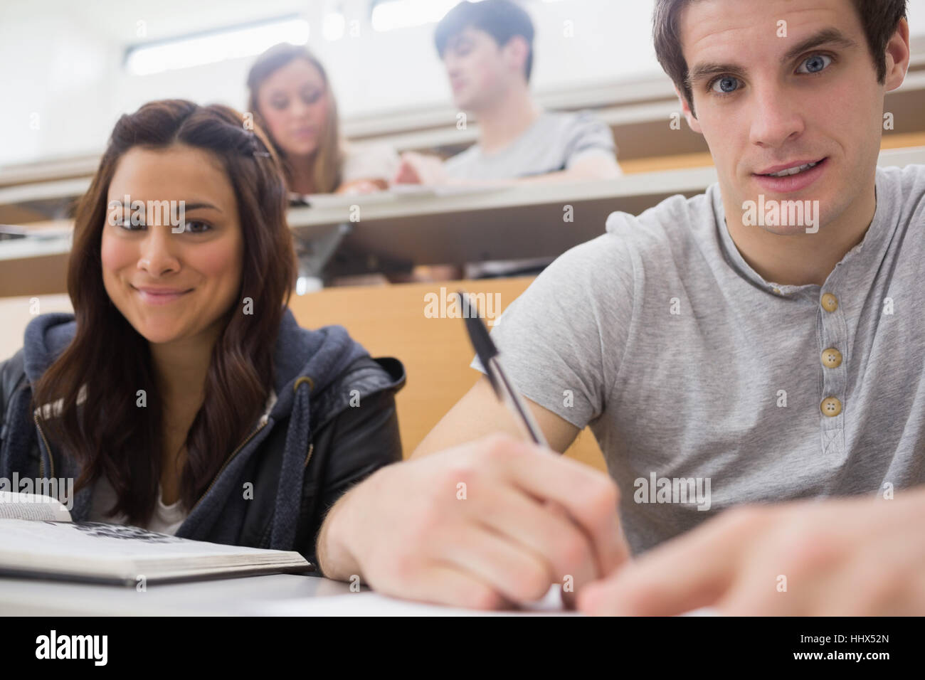Students sitting at the desk smiling at the lecture hall Stock Photo ...