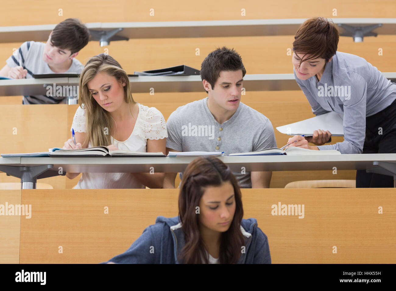 Students sitting at the lecture hall teacher explaining Stock Photo - Alamy