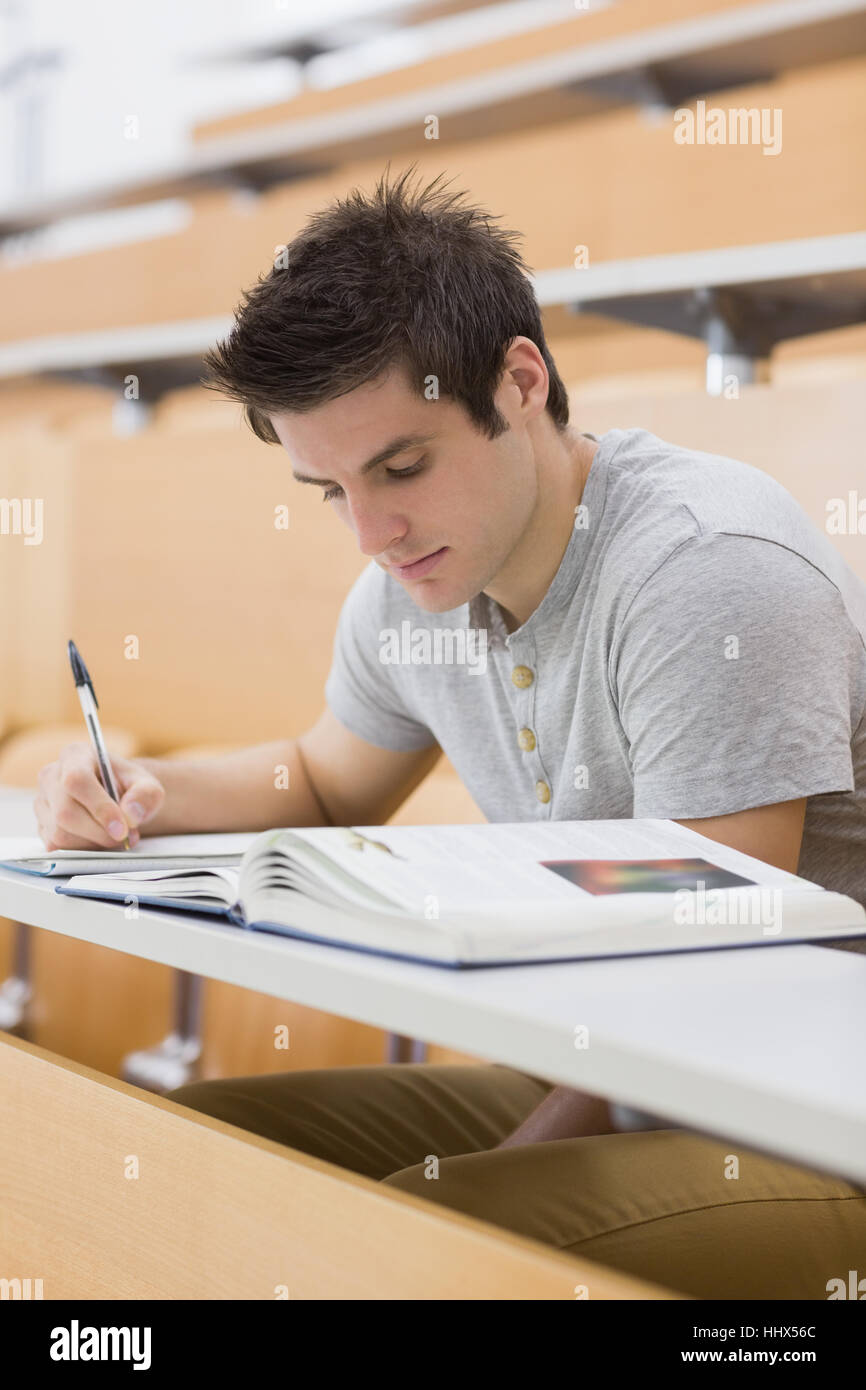 Man sitting at the lecture hall while writing Stock Photo - Alamy