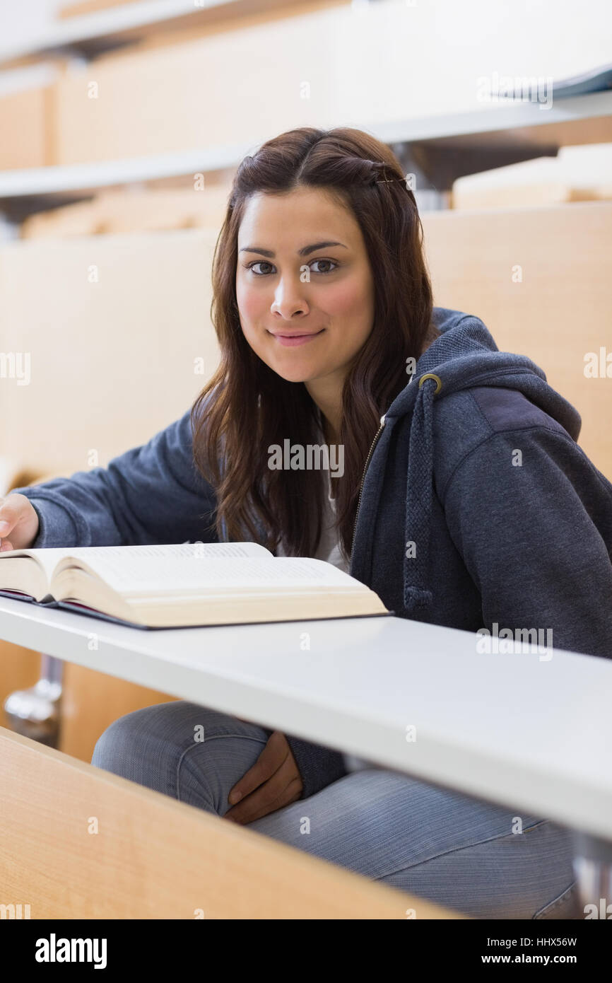 Woman sitting at the lecture hall reading a book Stock Photo - Alamy