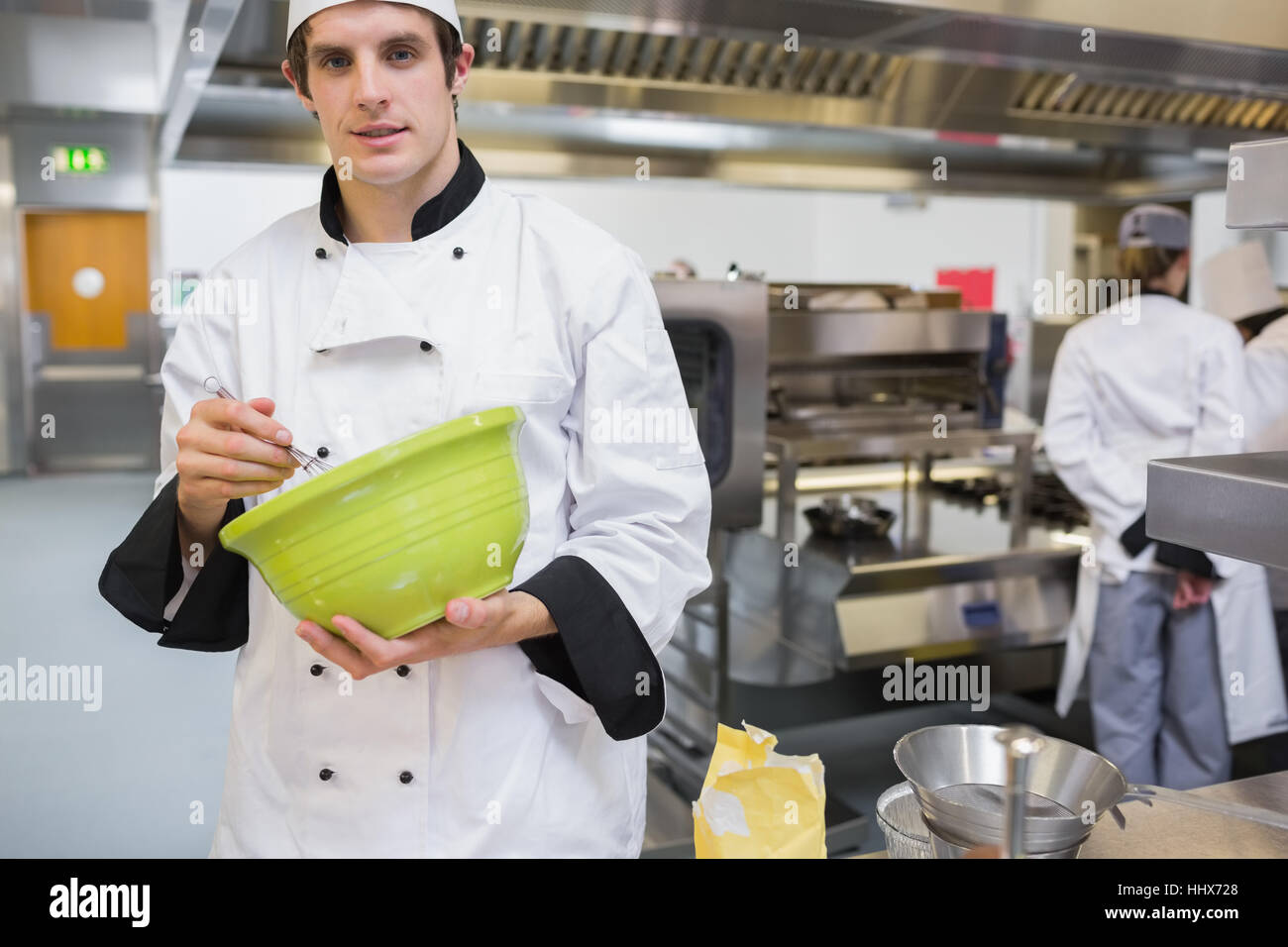 Chef mixing in the kitchen while smiling Stock Photo - Alamy
