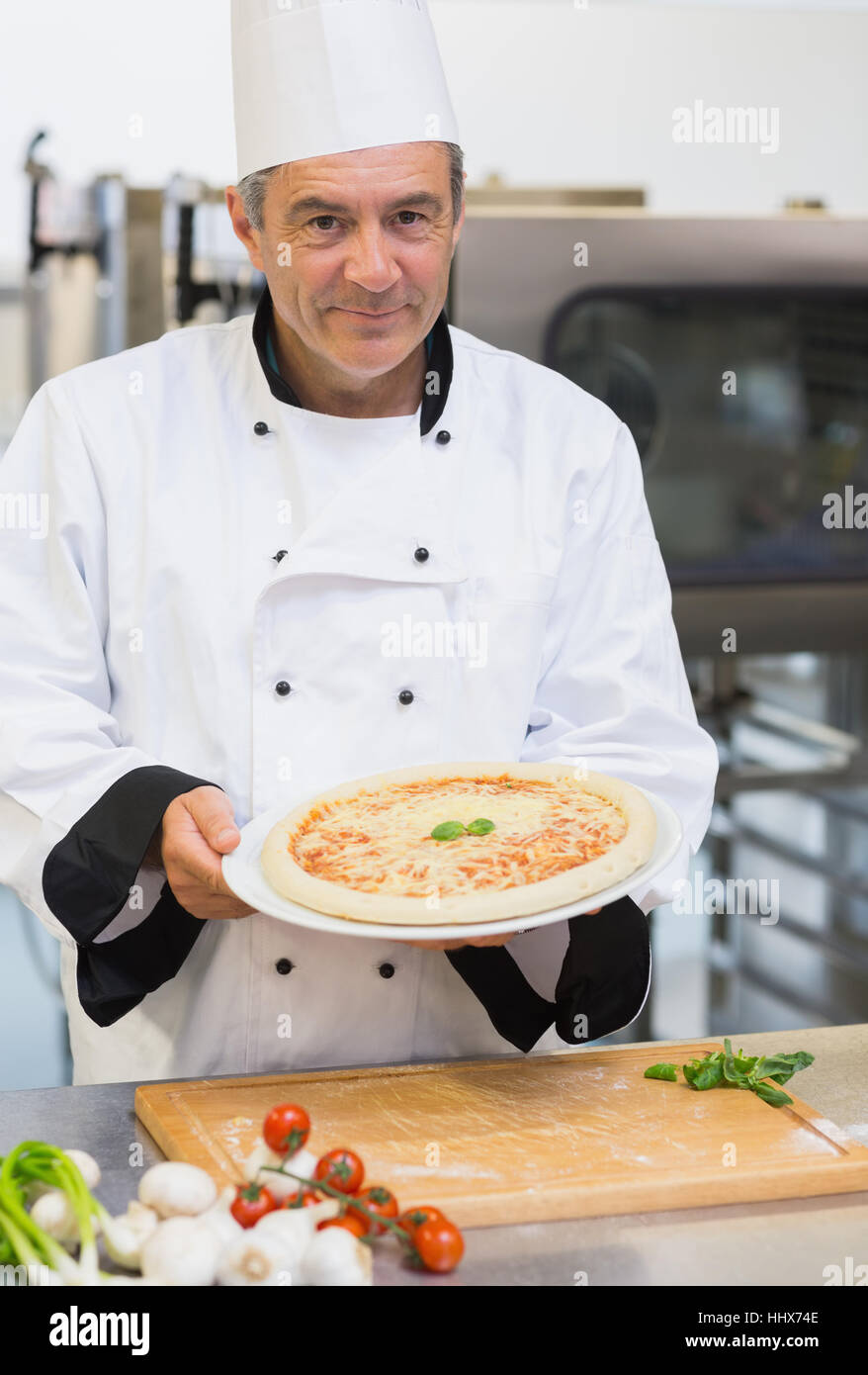 Cheerful chef presenting pizza in kitchen Stock Photo - Alamy