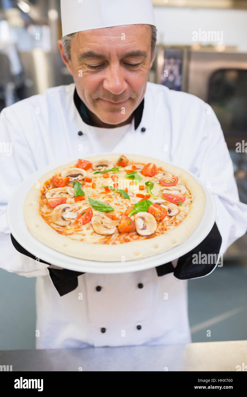 Chef smelling pizza in the kitchen Stock Photo - Alamy