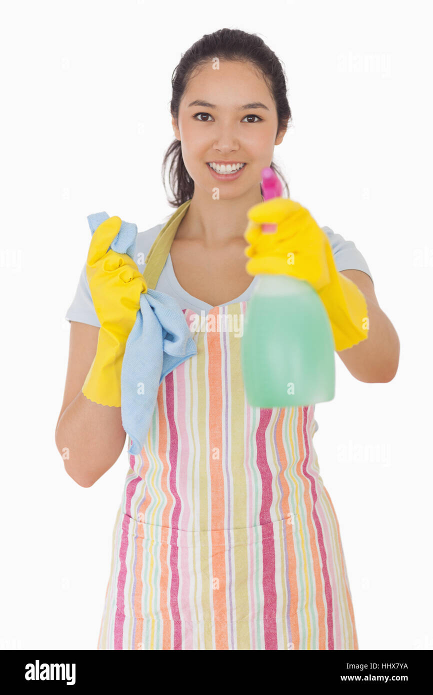 Smiling woman in apron holding out spray bottle Stock Photo - Alamy