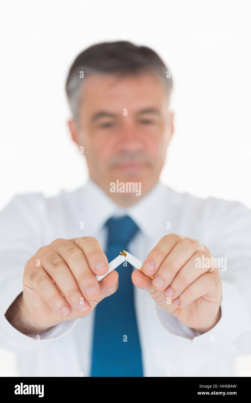 Man concentrating on breaking cigarette in half Stock Photo - Alamy