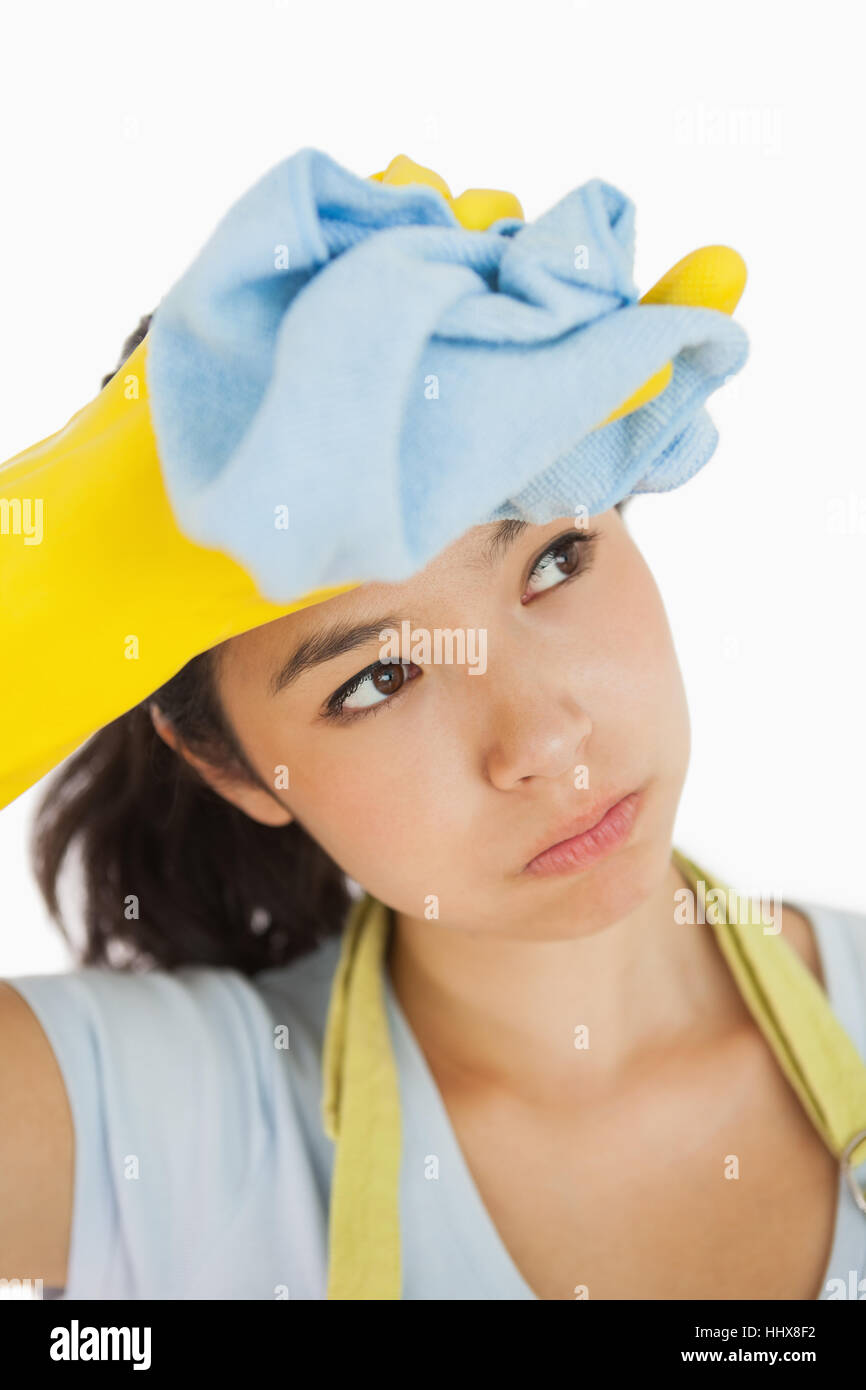 Woman wiping her brow wearing rubber gloves and an apron Stock Photo ...