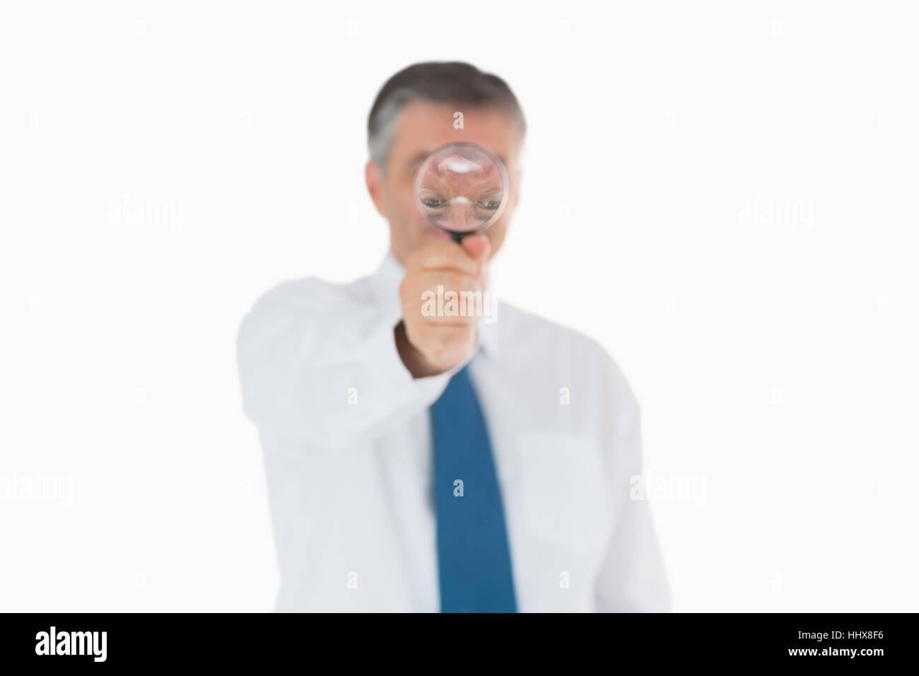 Businessman in shirt and tie behind magnifying glass Stock Photo - Alamy