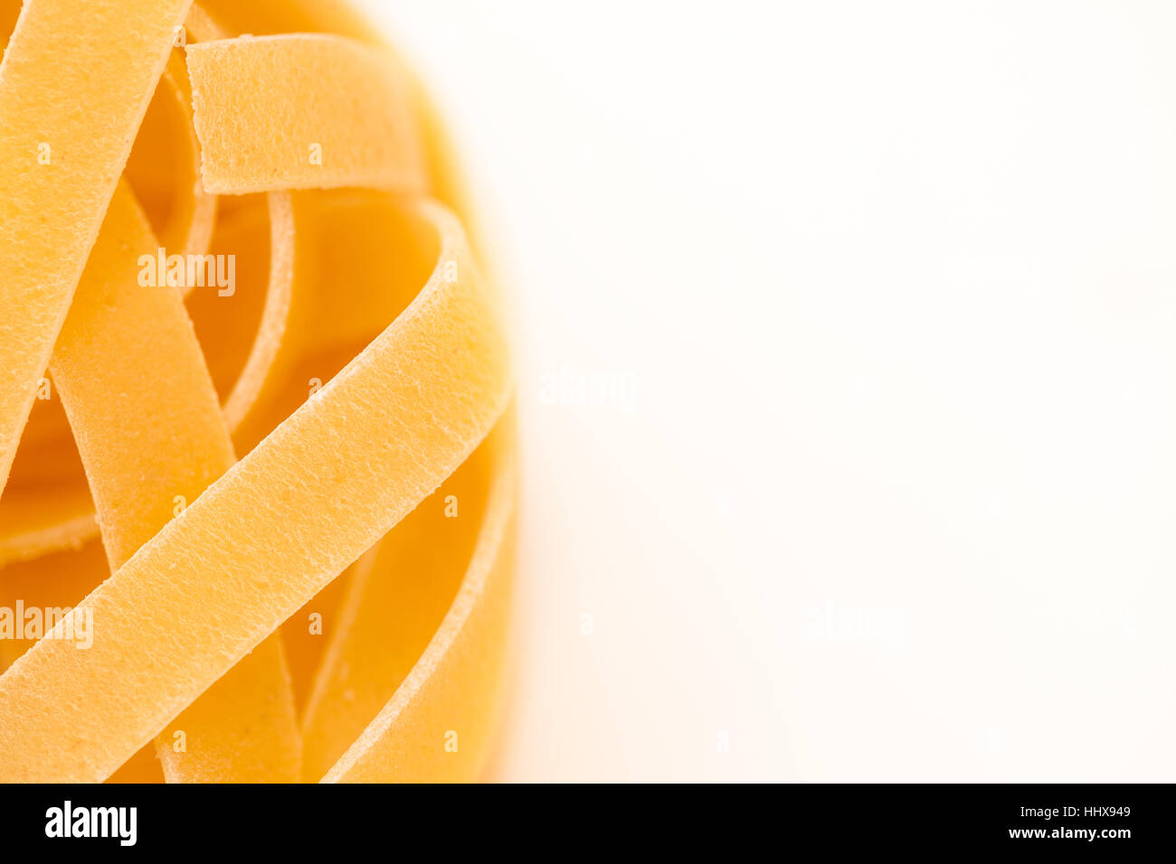 Close up dry tagliatelle on white background Stock Photo - Alamy