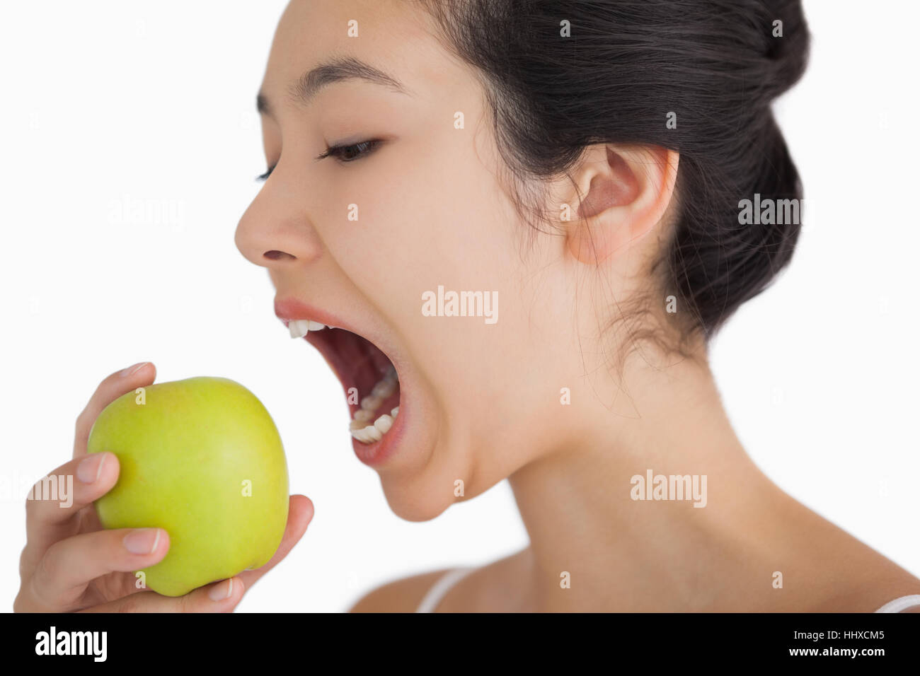 Woman biting into a green apple Stock Photo - Alamy