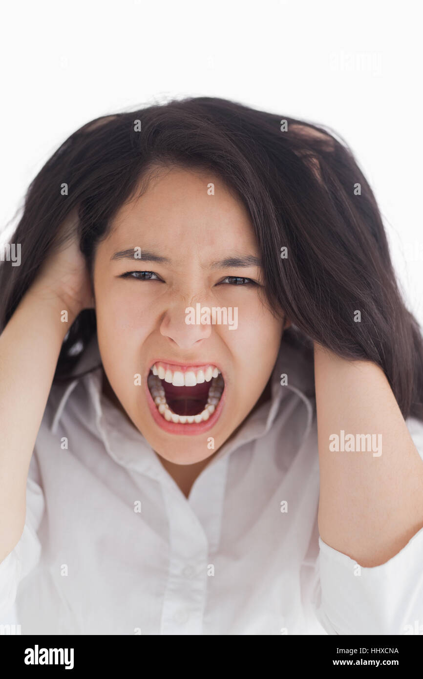 Screaming brunette pulling her hair on white background Stock Photo - Alamy