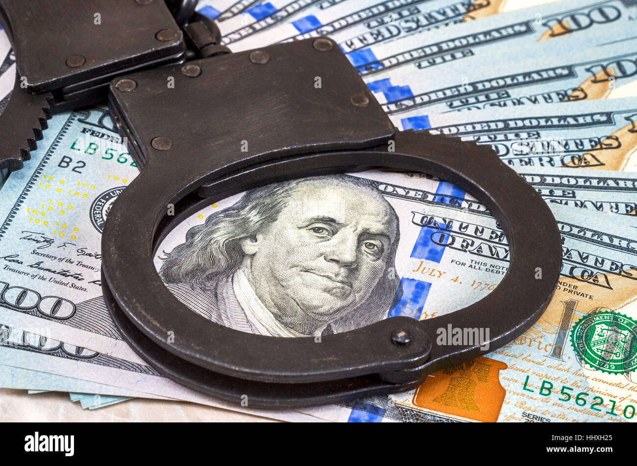 Steel police handcuffs lying on the background of american dollars ...