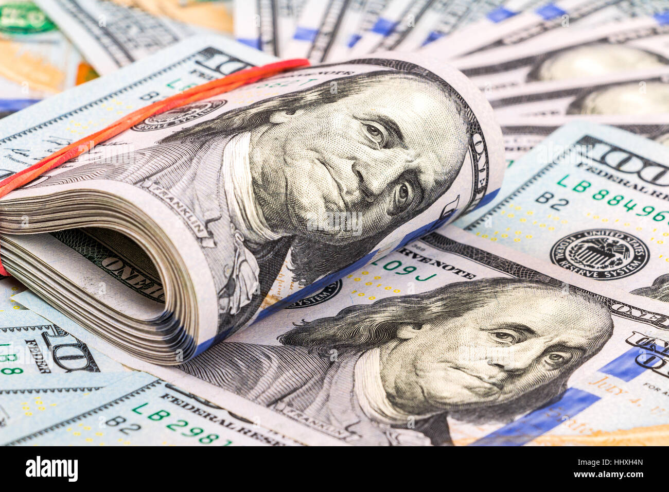 Folded dollar bills wrapped by rubber band over dollars banknotes Stock ...