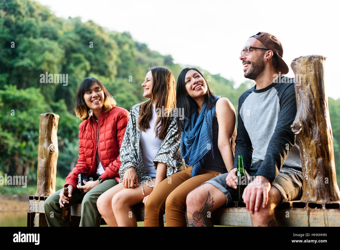 Friends Sitting in a Row Outdoors Concept Stock Photo - Alamy