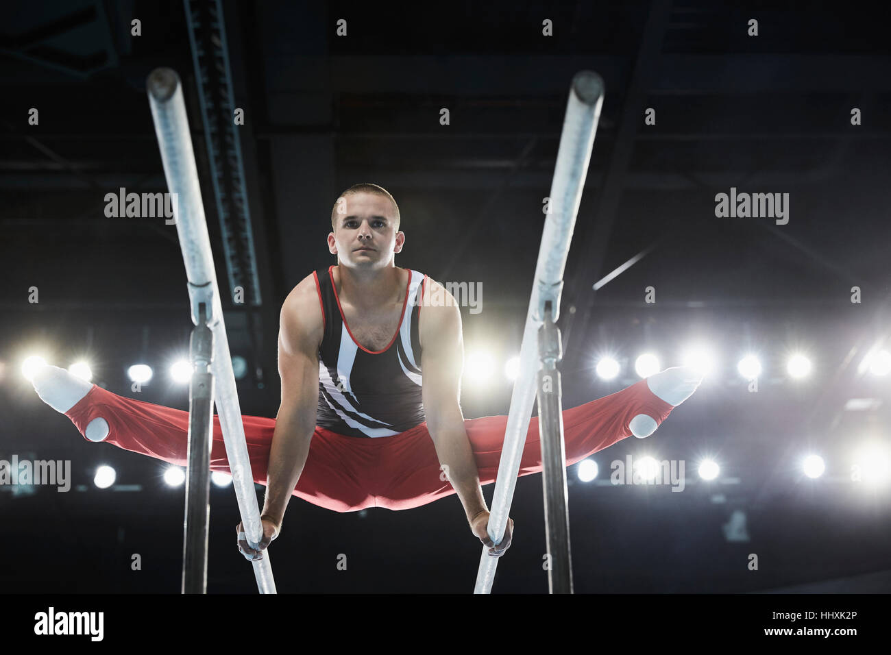 Male gymnast performing splits on parallel bars Stock Photo - Alamy