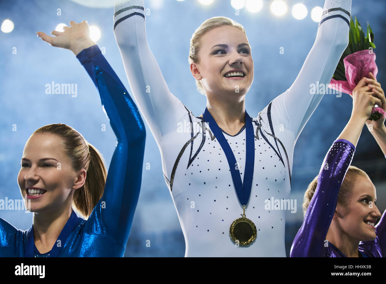 Female gymnasts celebrating victory waving on winners podium Stock ...
