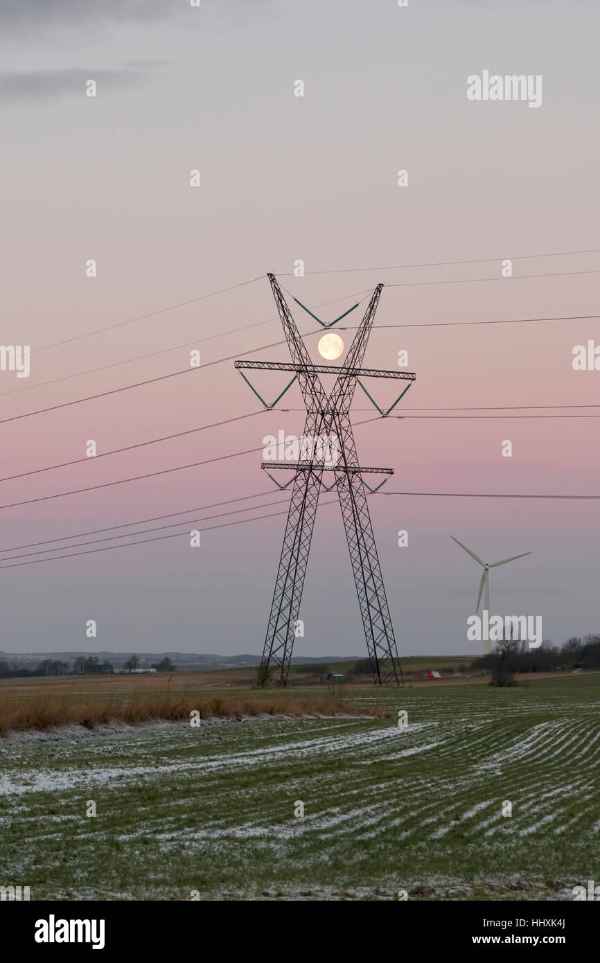 Full moon behind a power pylon at sunset Stock Photo - Alamy