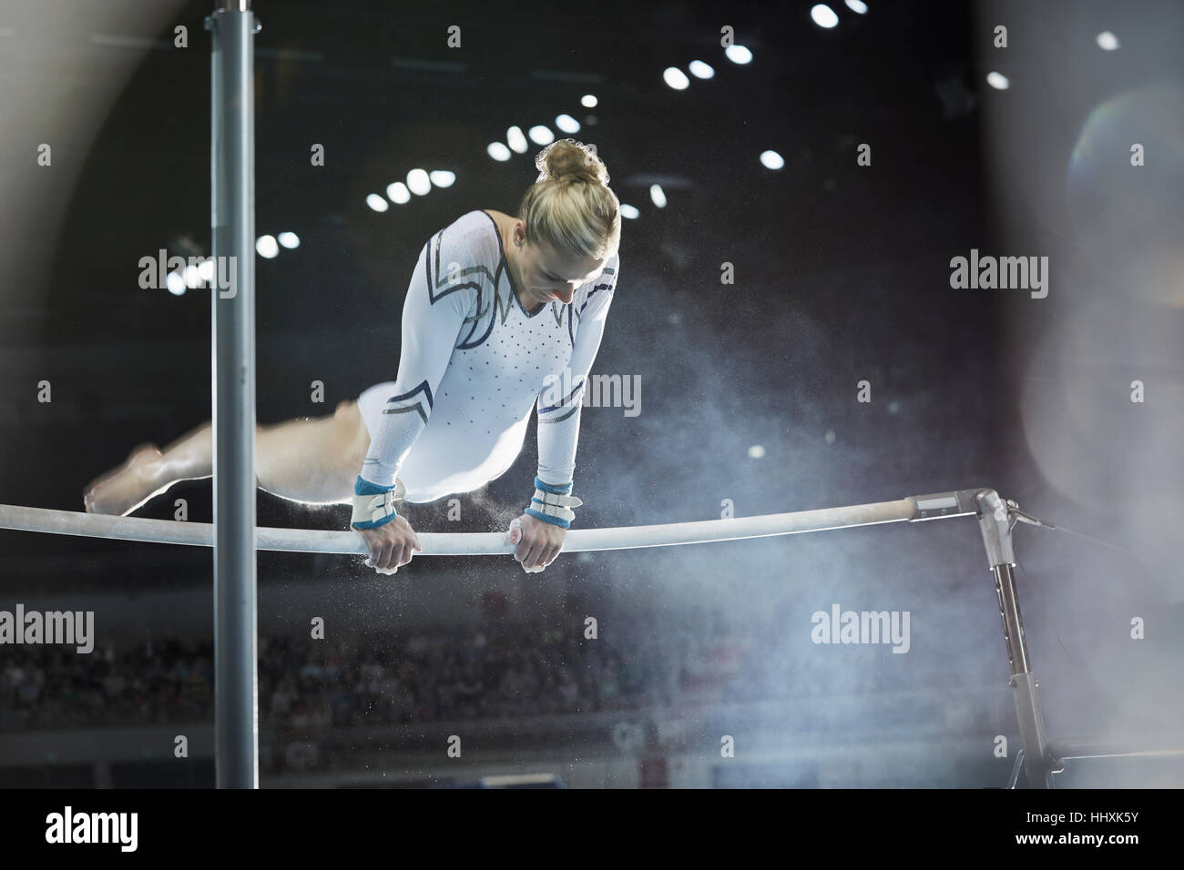 Female gymnast performing on uneven bars in arena Stock Photo - Alamy