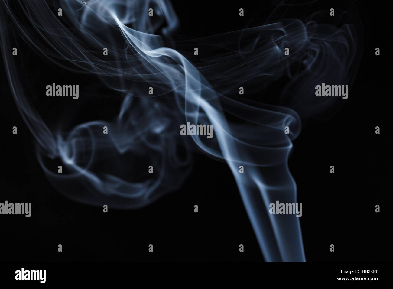 White and coloured aromatic stick burned smoke on black background ...