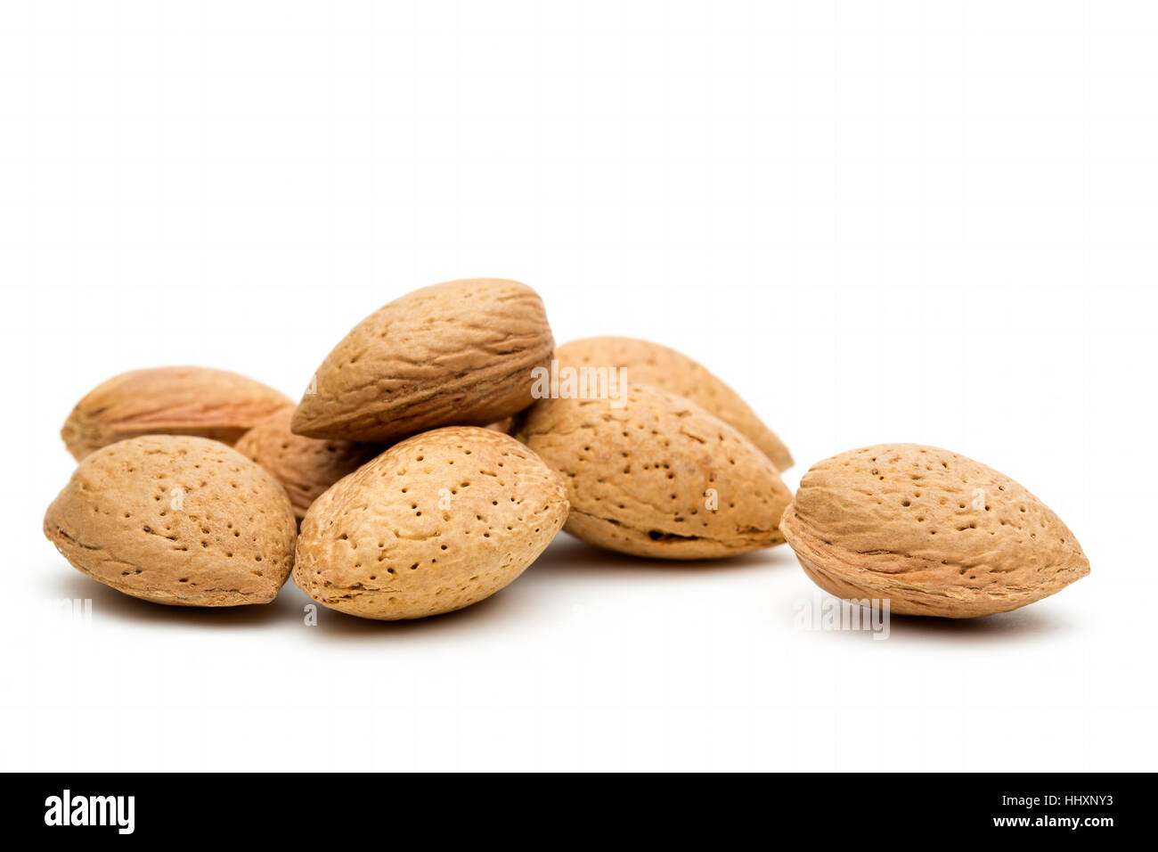 Pile of almonds in shells on a white background Stock Photo - Alamy