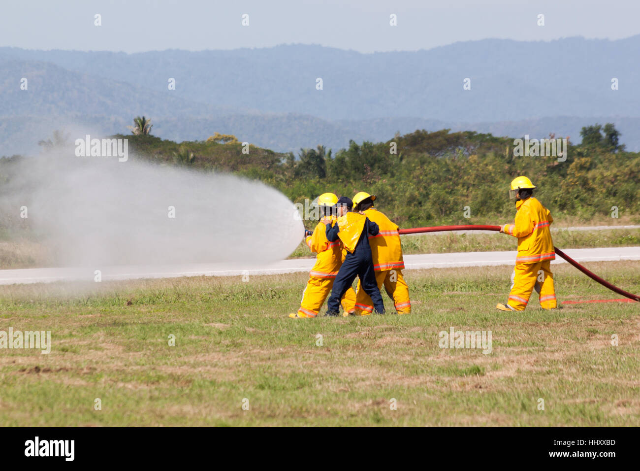 Firefighter in action spraying fire with fire hose Stock Photo - Alamy