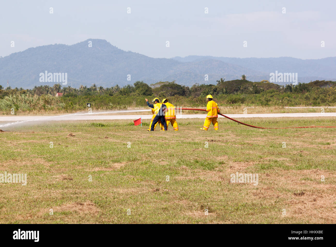 Firefighter in action spraying fire with fire hose Stock Photo - Alamy