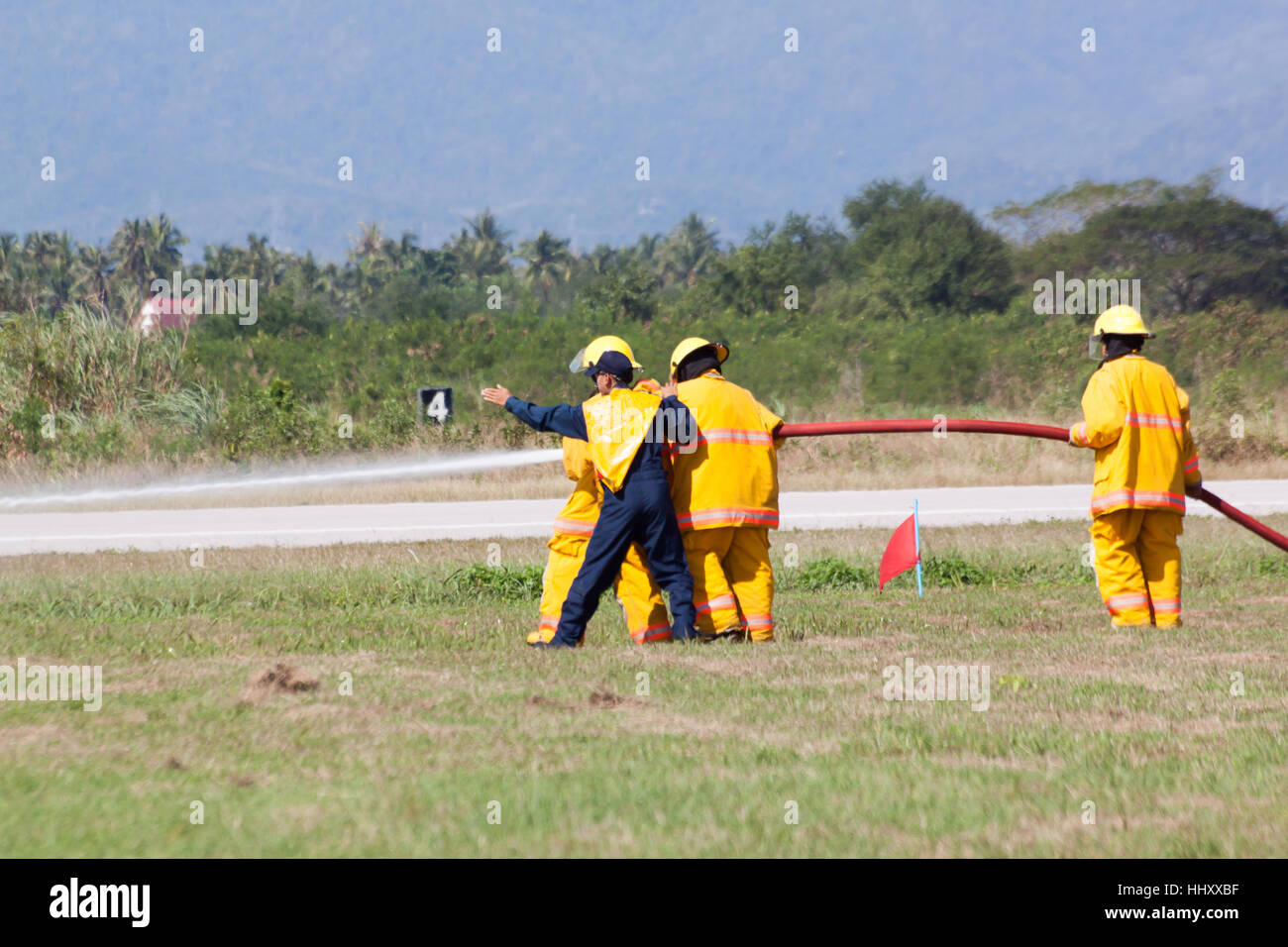 Firefighter in action spraying fire with fire hose Stock Photo - Alamy