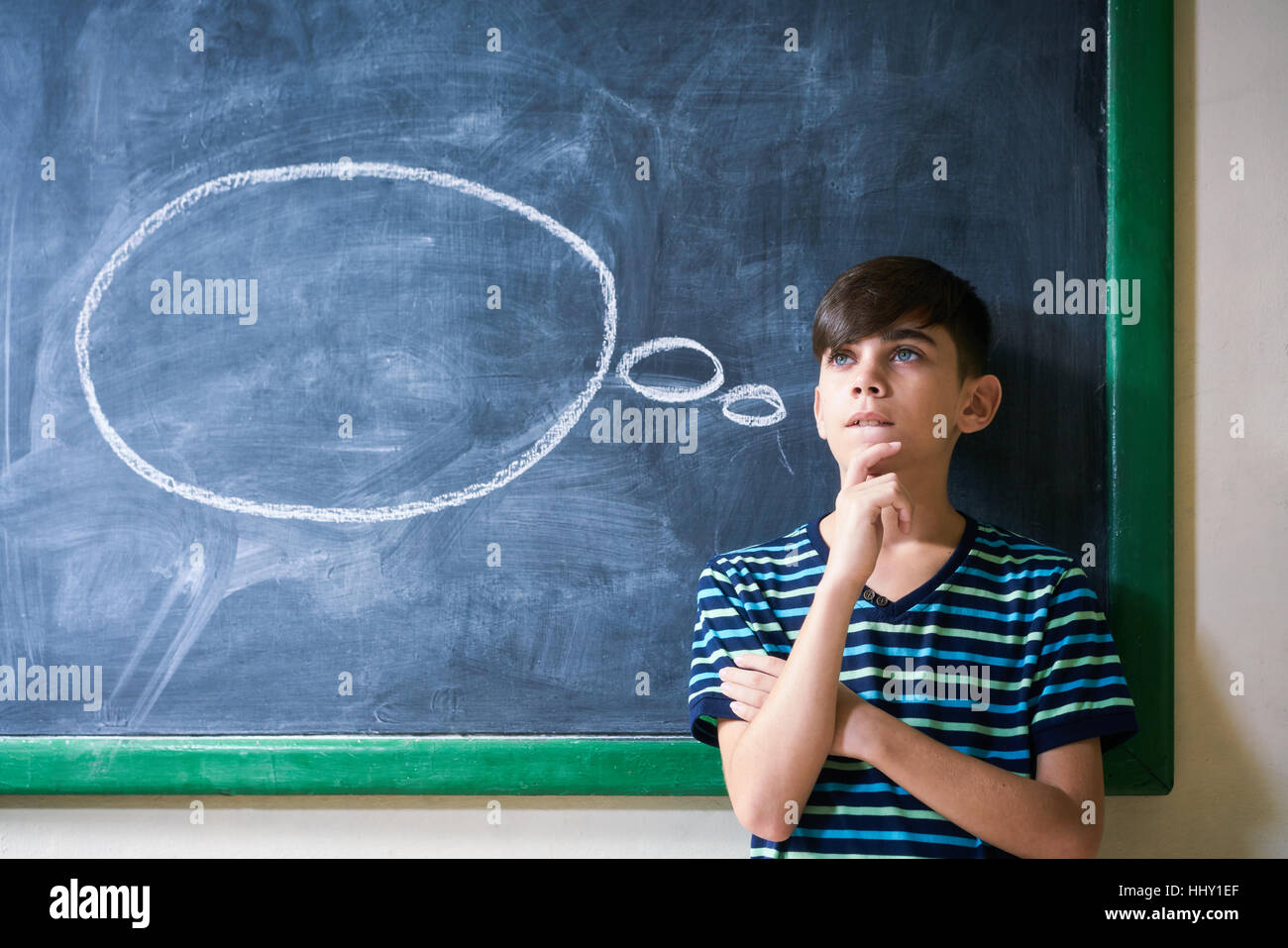 Concepts on blackboard at school. Intelligent and smart hispanic boy in ...
