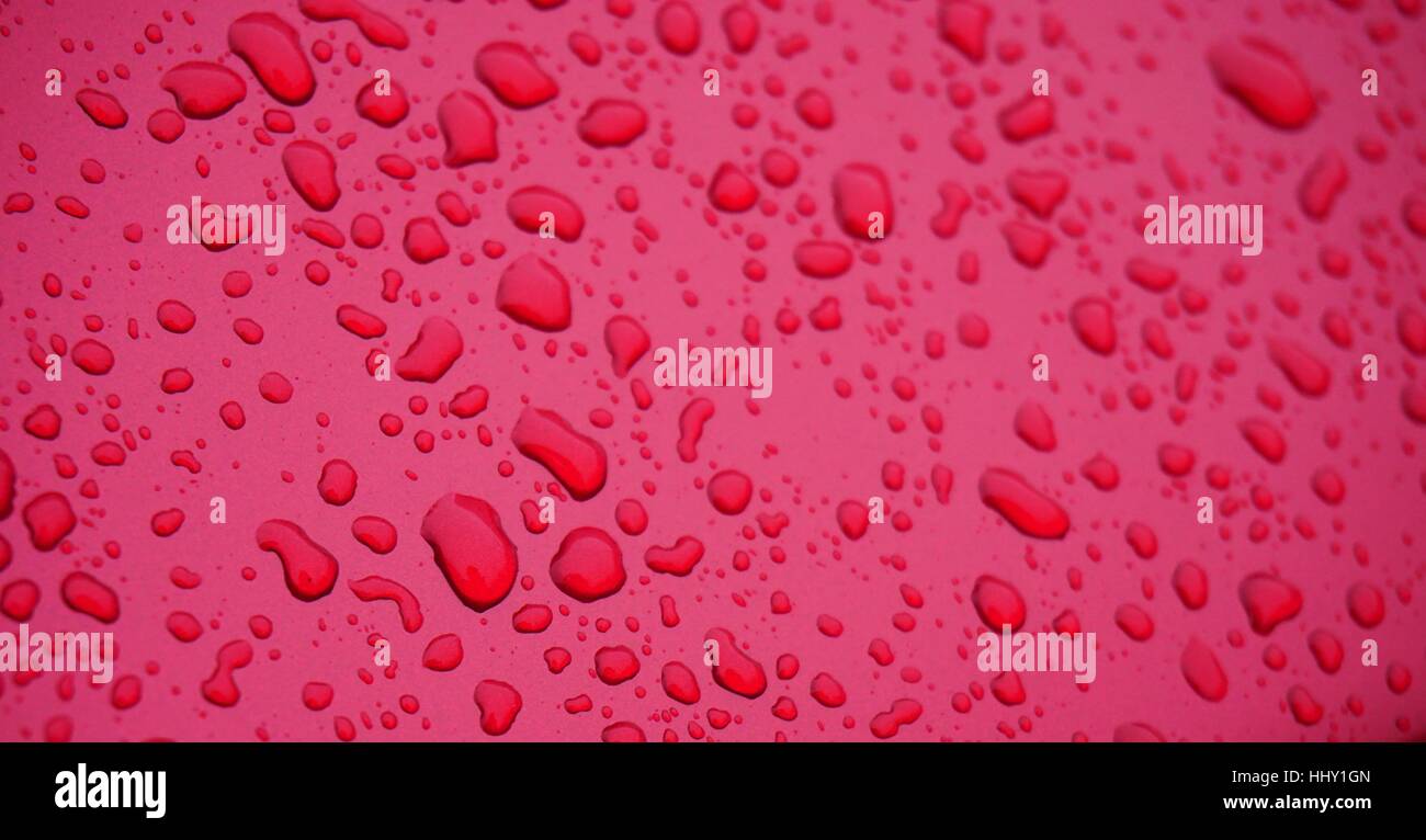Droplets of rain on a red metallic background Stock Photo - Alamy