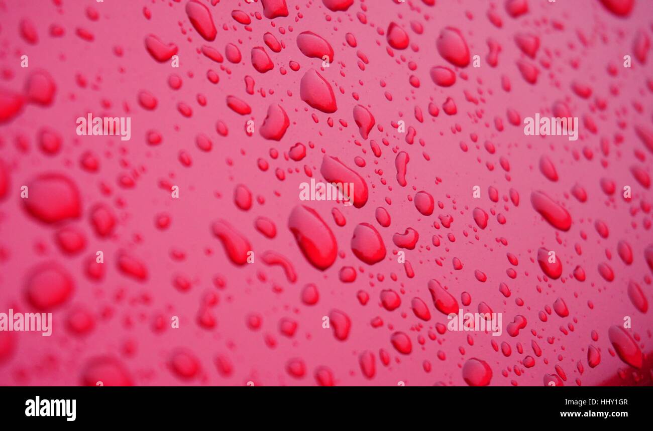 Droplets of rain on a red metallic background Stock Photo - Alamy