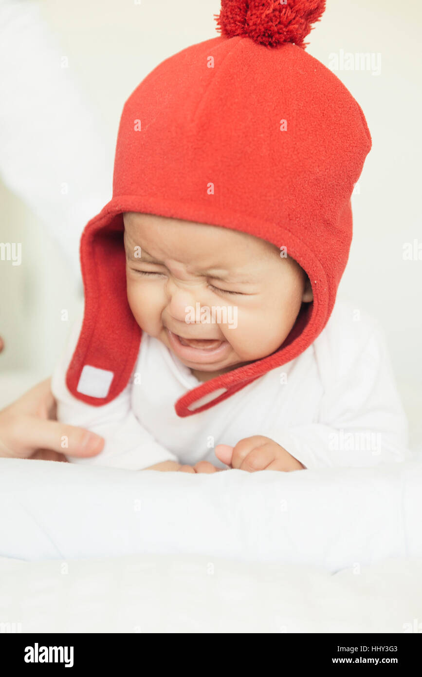 Cute Baby Girl Crying in the Crib. At home Stock Photo - Alamy