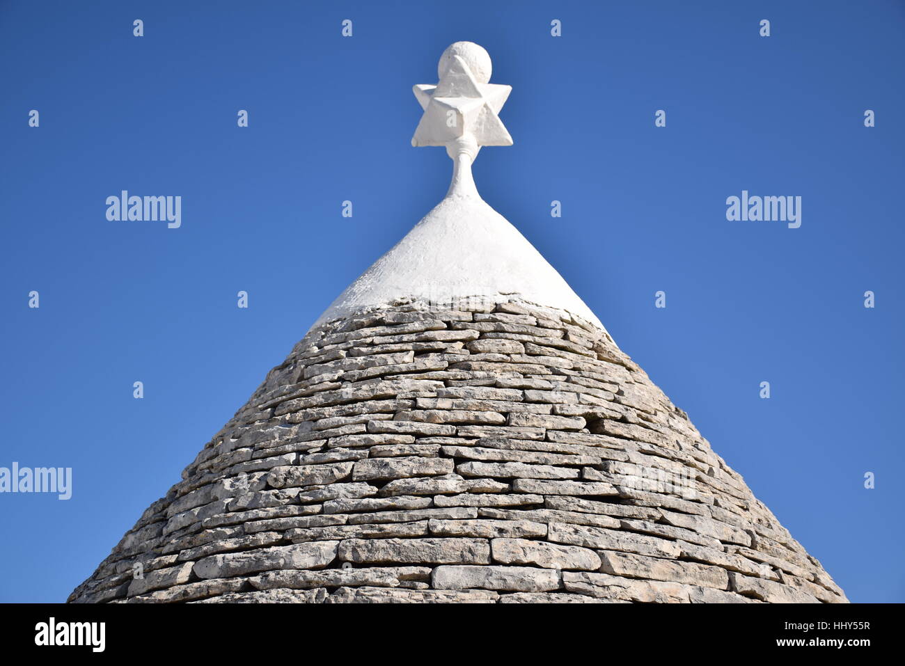 The typical conical roof of trulli houses and its symbols in ...