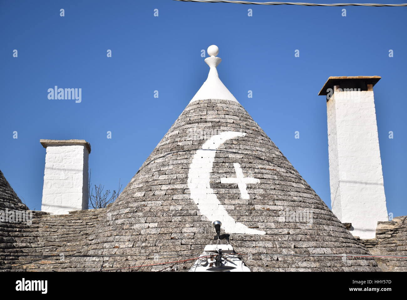 The typical conical roof of trulli houses and its symbols in ...