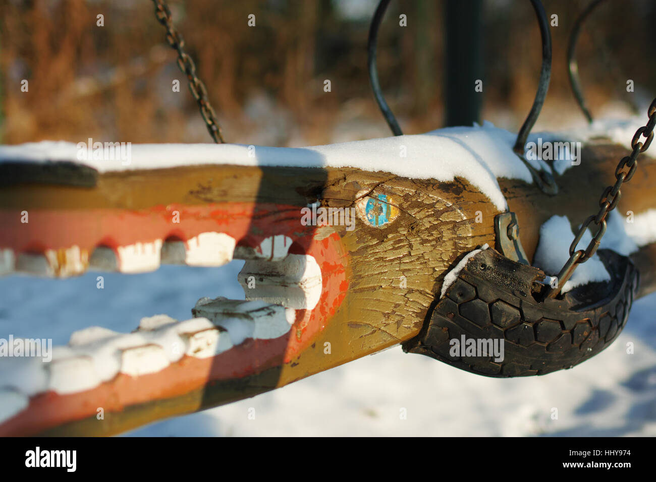 crocodile wooden swing playground in winter Stock Photo - Alamy