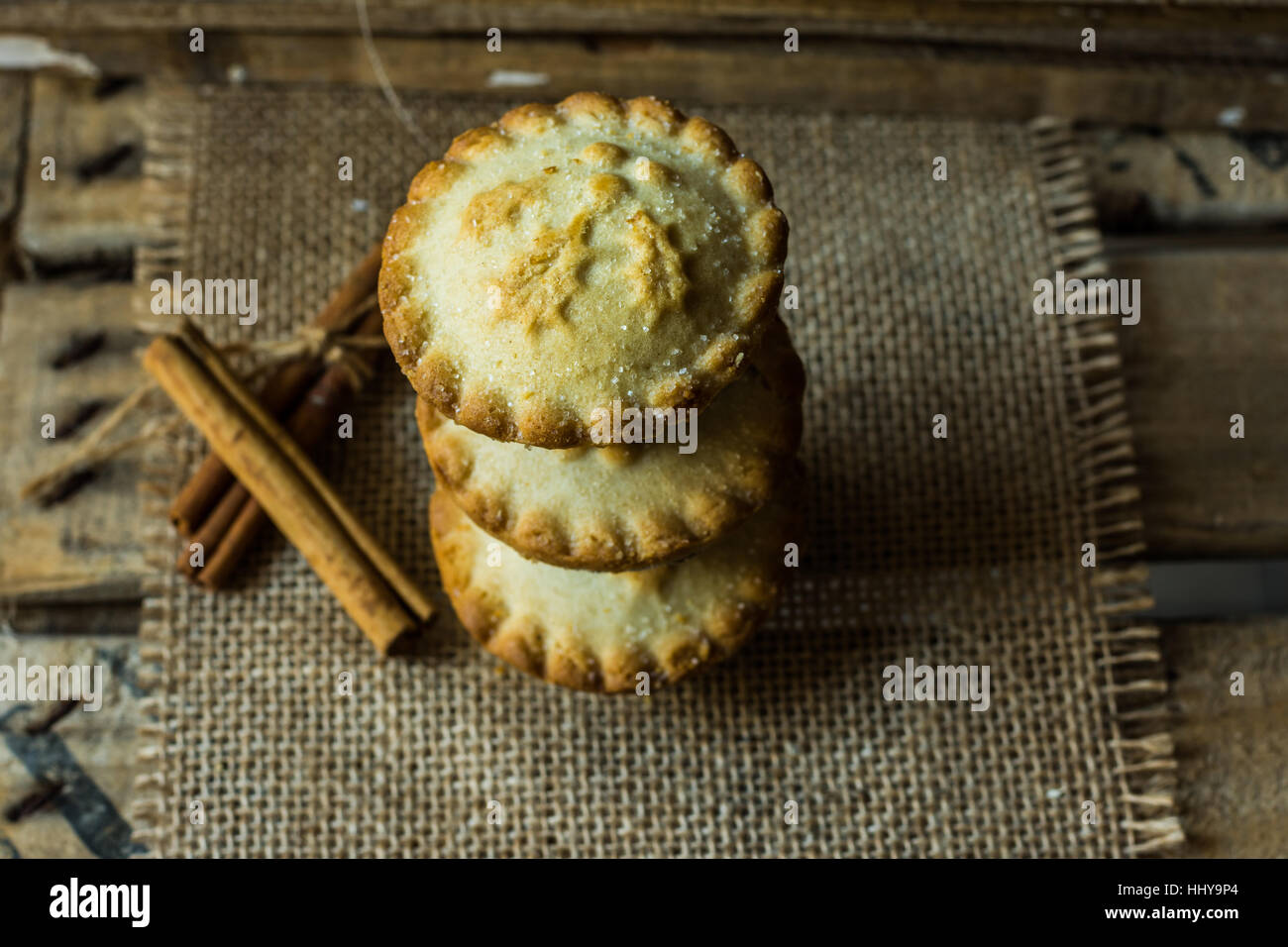 Stack of sweet mince pies on sackcloth with cinnamon sticks on a ...