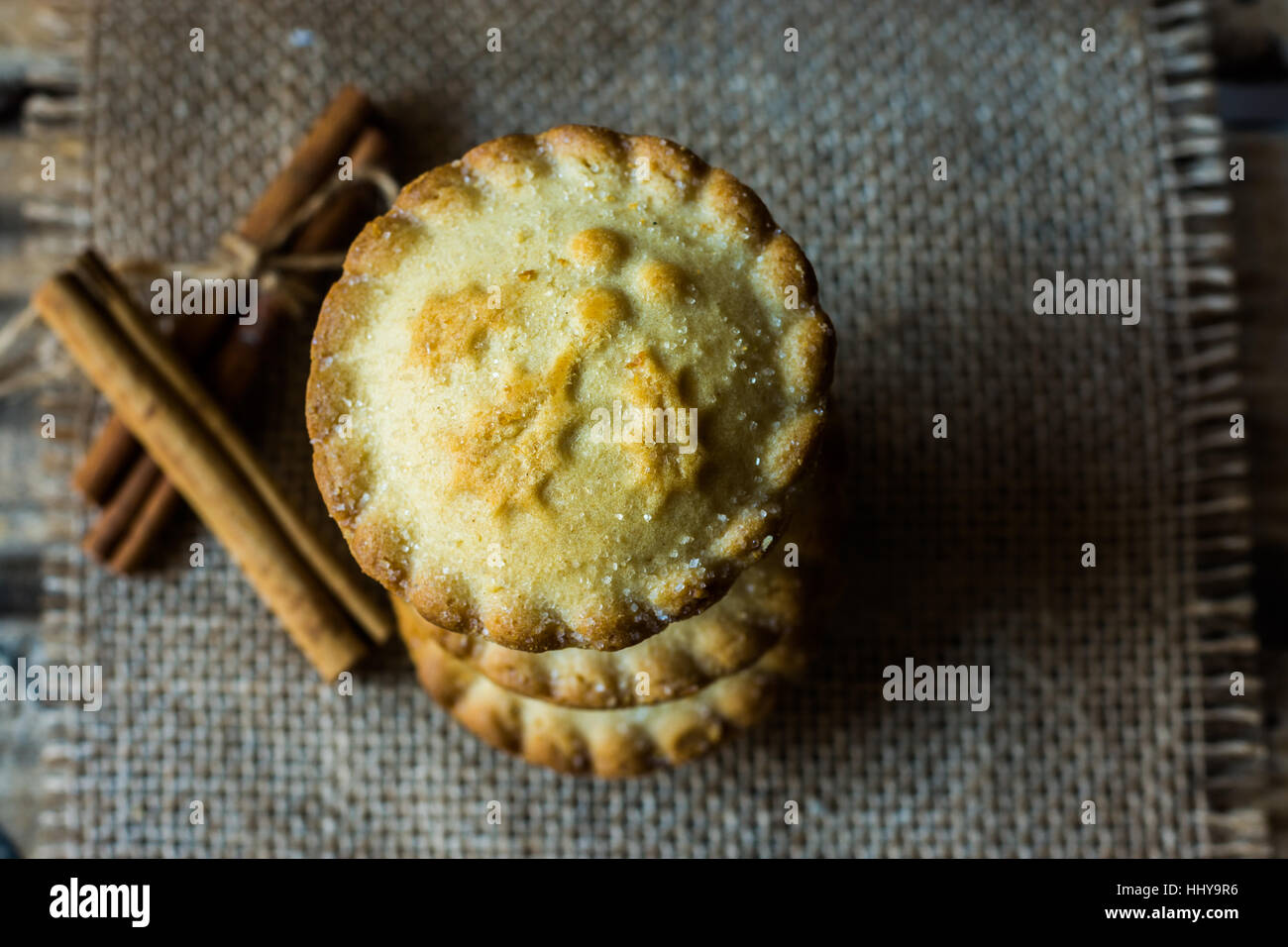 Stack of Christmas mince pies on sackcloth on a vintage wood box, with ...