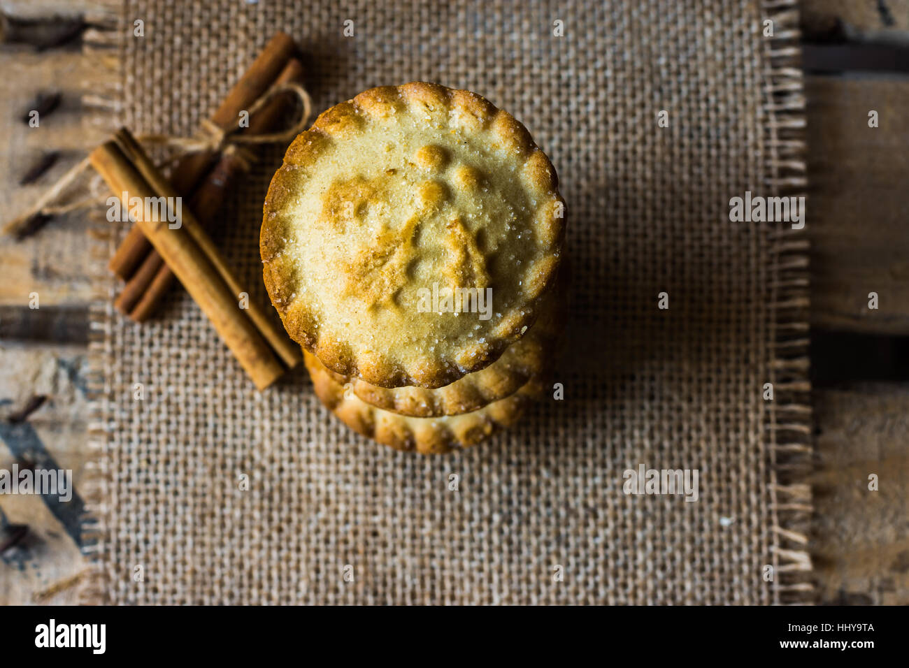 Stack of Christmas mince pies on sackcloth on a vintage wood box, with ...