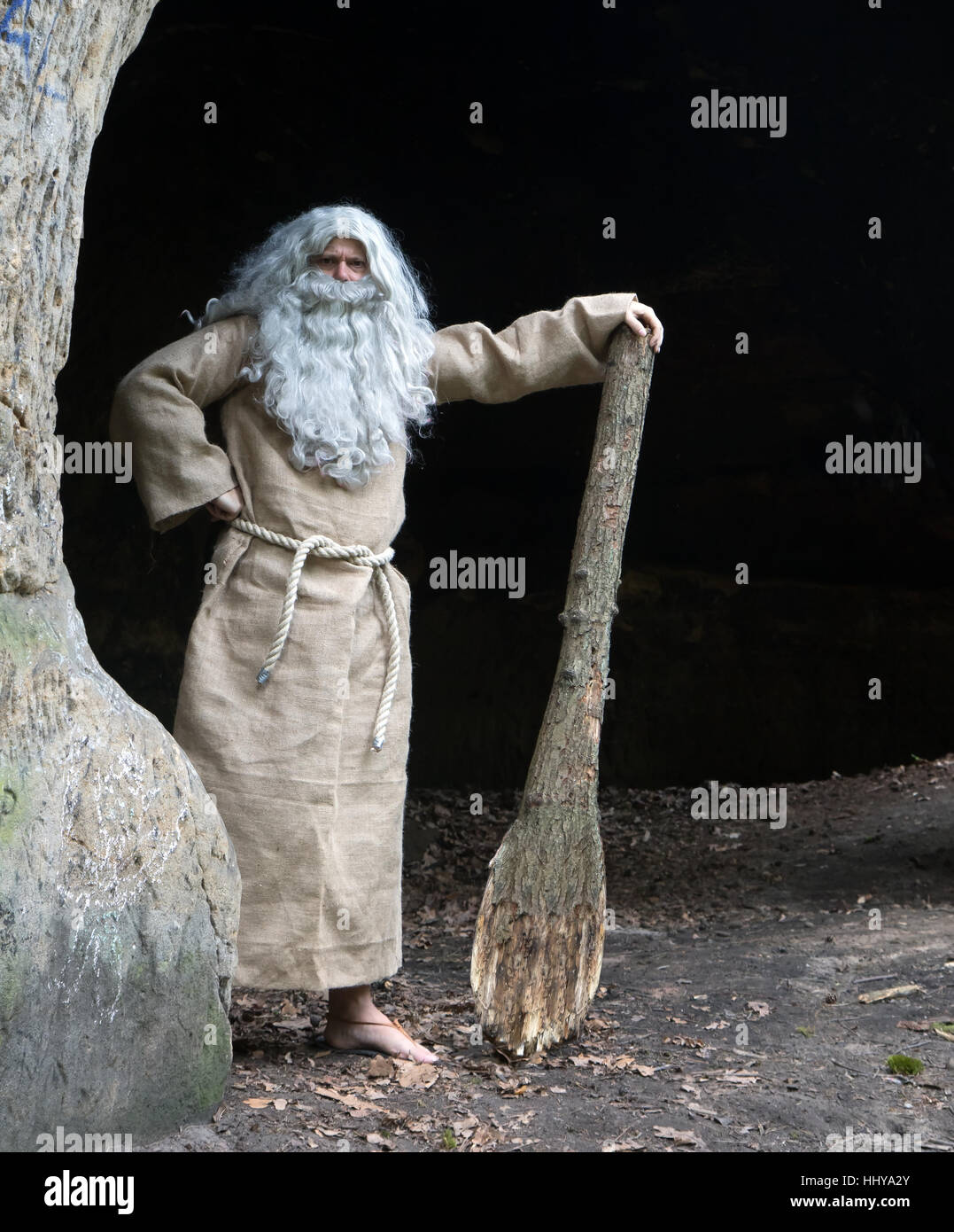 bearded hermit in a cave stands with club in hand Stock Photo - Alamy