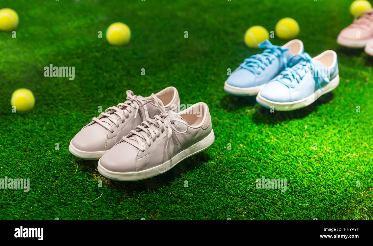 Sport shoes and tennis balls on a grass Stock Photo - Alamy