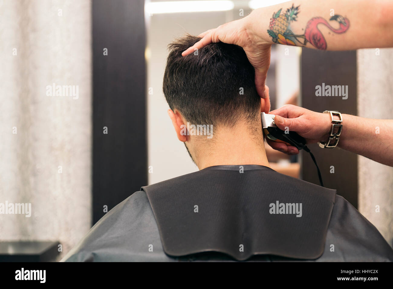 Hairstylist making men's haircut to an attractive man in the beauty ...