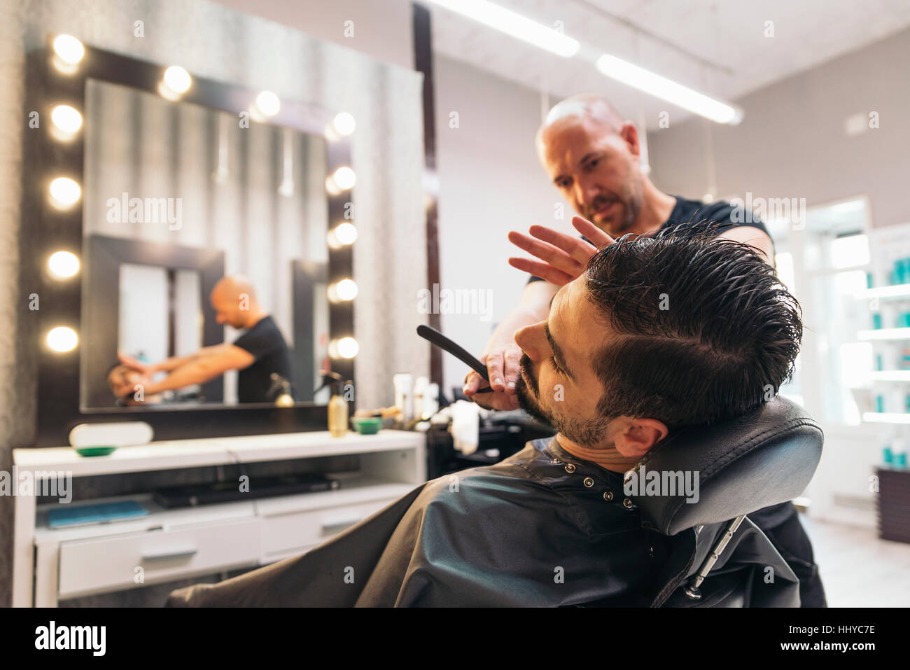 Young Bearded Man Getting Beard Haircut With A Razor By Barber ...