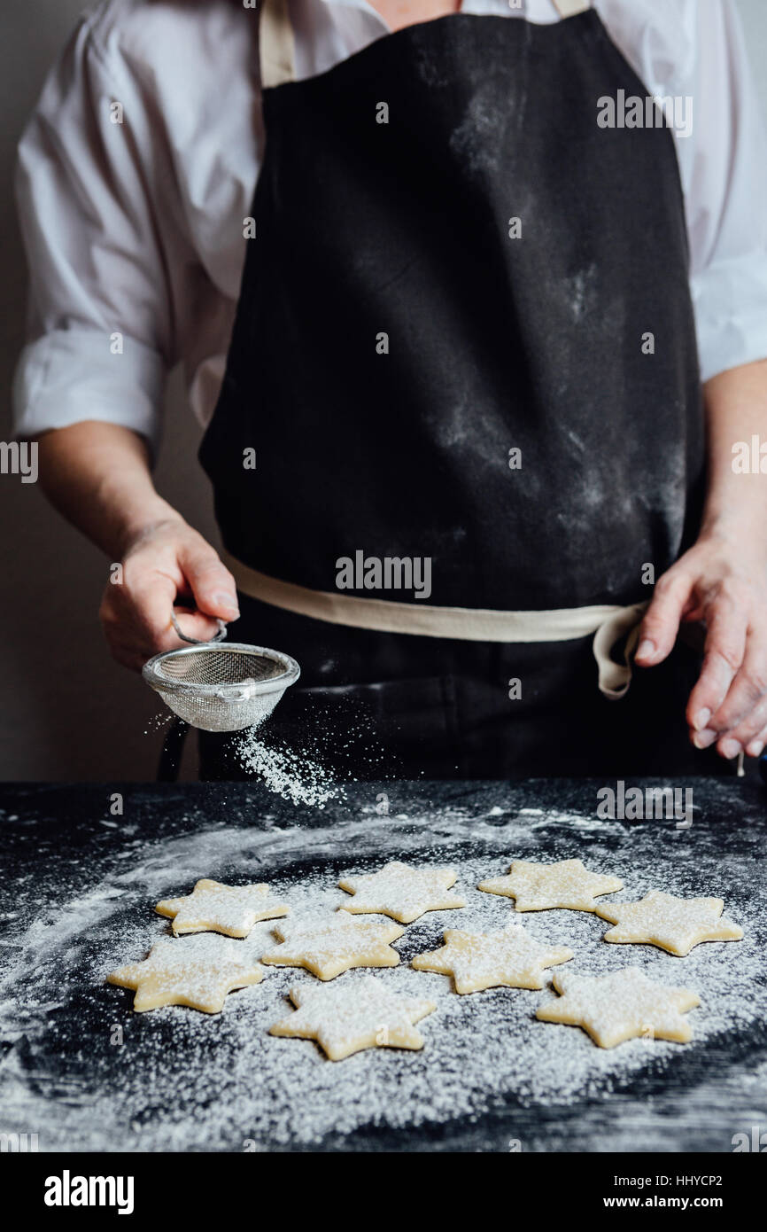 Person putting raw cookies to flour Stock Photo - Alamy