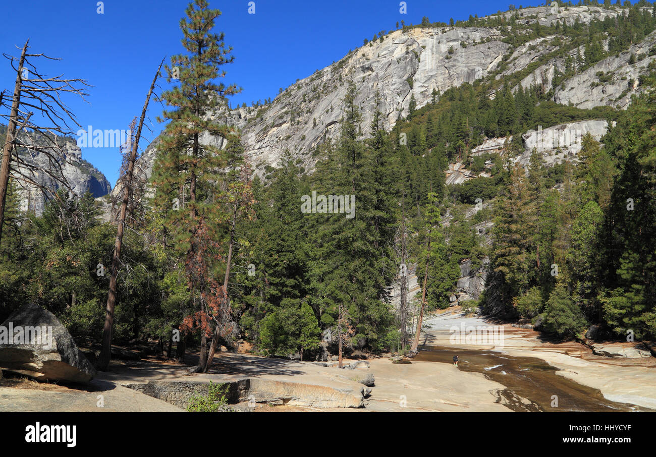 A lone hiker stops at the edge of Merced River as it flows towards ...