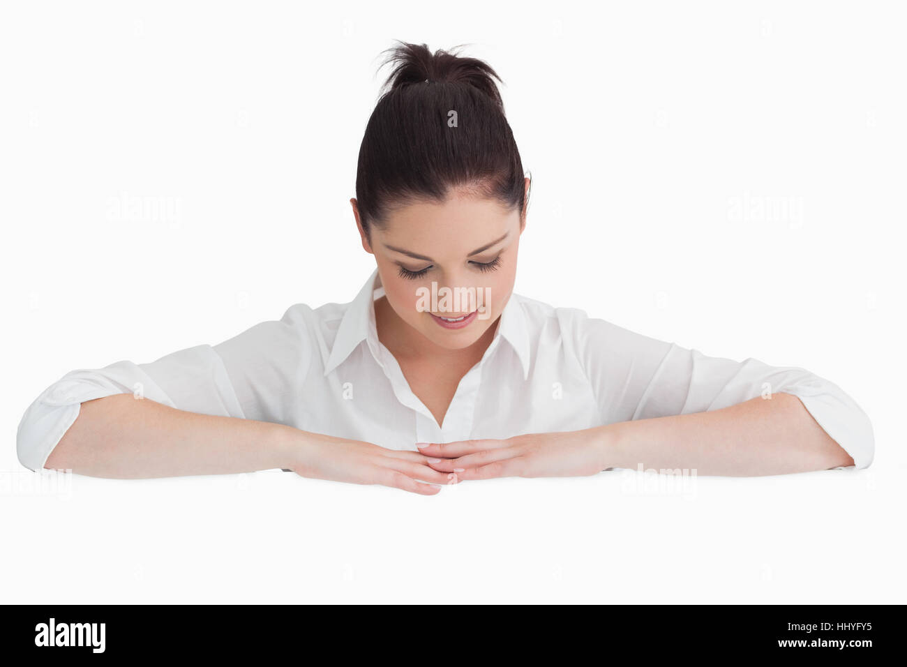 Woman leaning on her arms and looking down on white background Stock ...