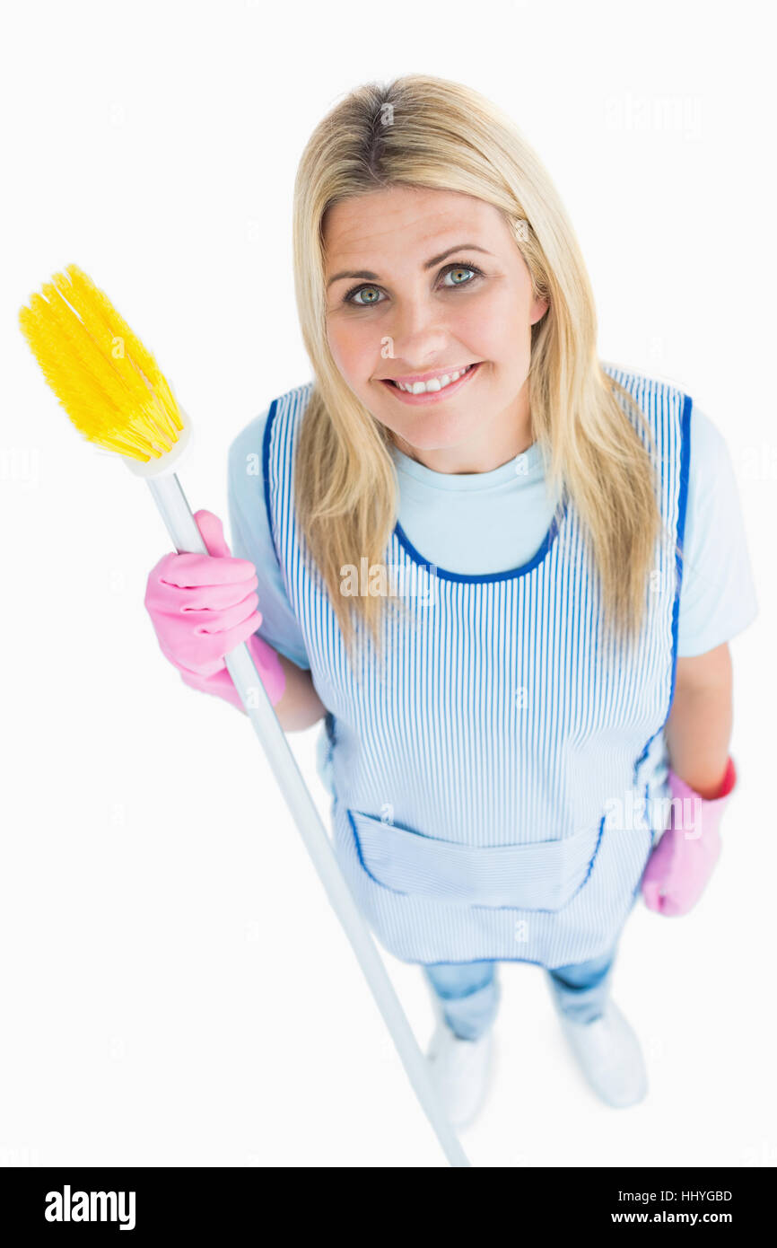 Happy cleaner woman holding a broom in the white background Stock Photo ...