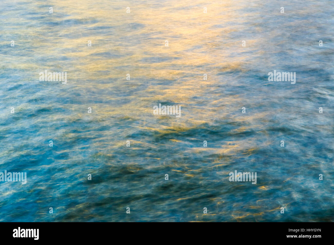 Abstract golden light reflecting on blue water Stock Photo - Alamy