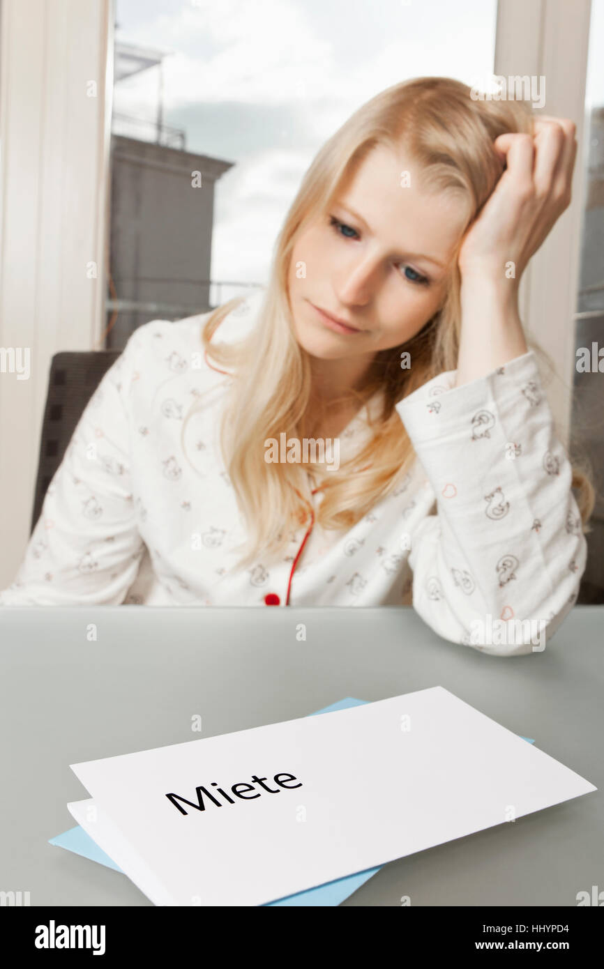 woman in her apartment looks desperate letter with rent due Stock Photo ...