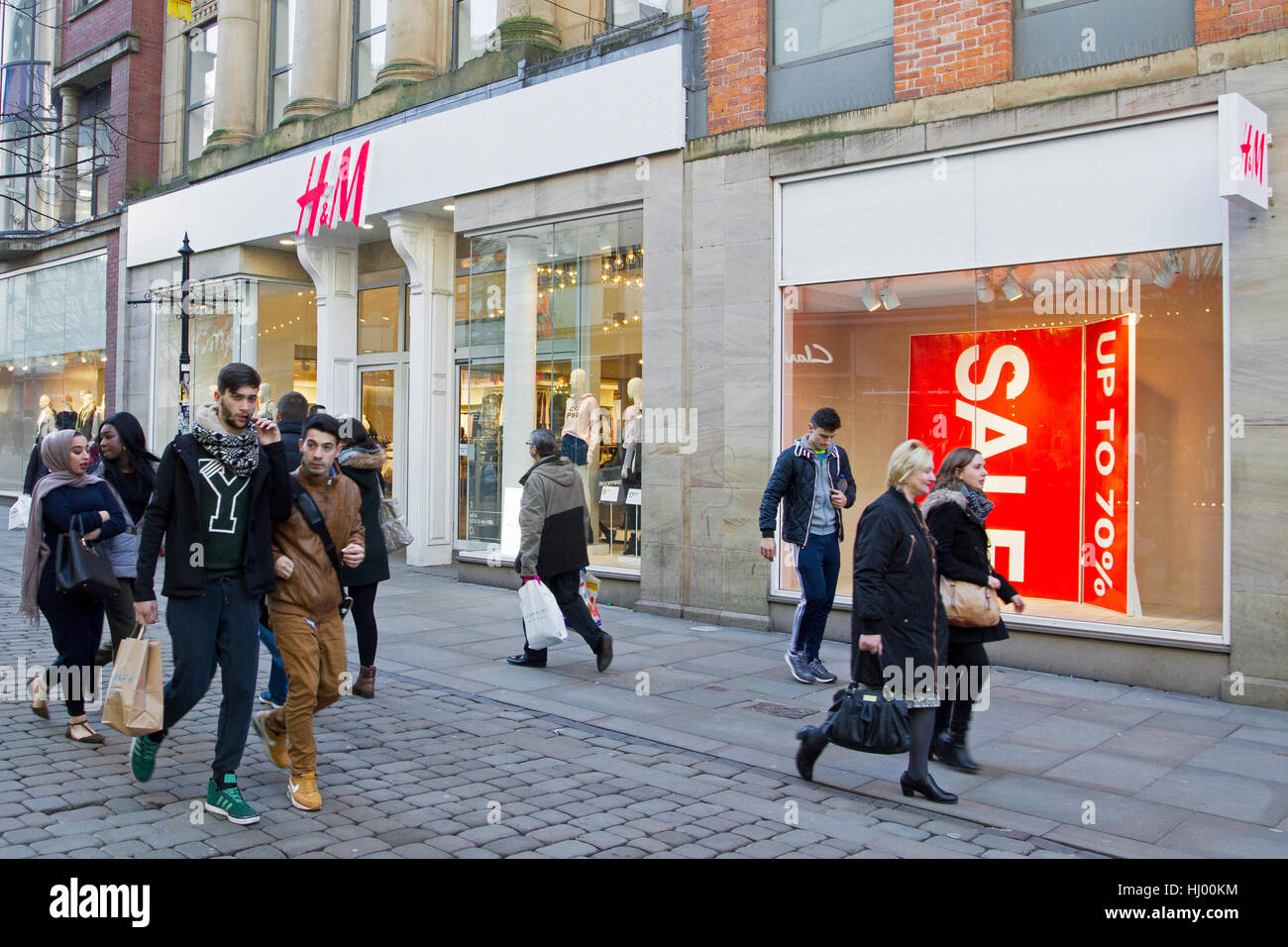 People walking past sale and reduction signs in shop windows Stock ...