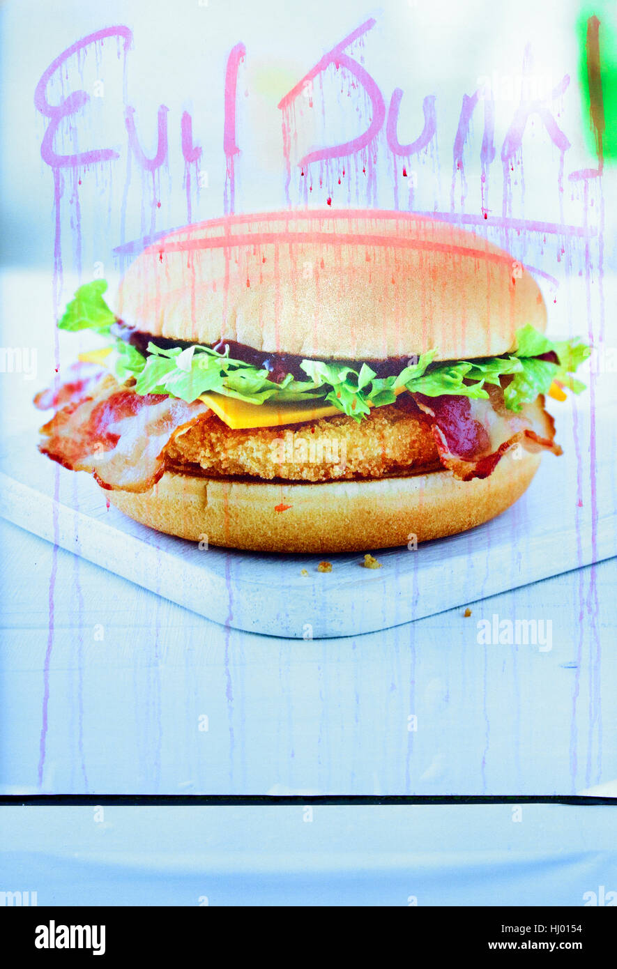 Defaced poster describing burger & chips as Junk Food. Vegetarianism ...